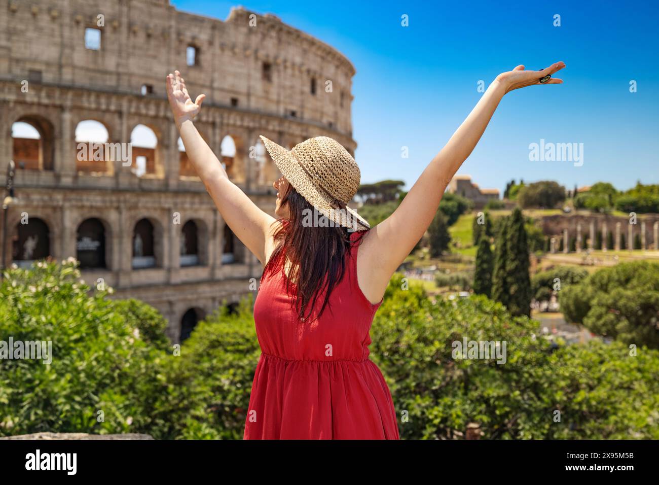Happy girl with straw hat visiting Rome rejoices and raises her arms in ...