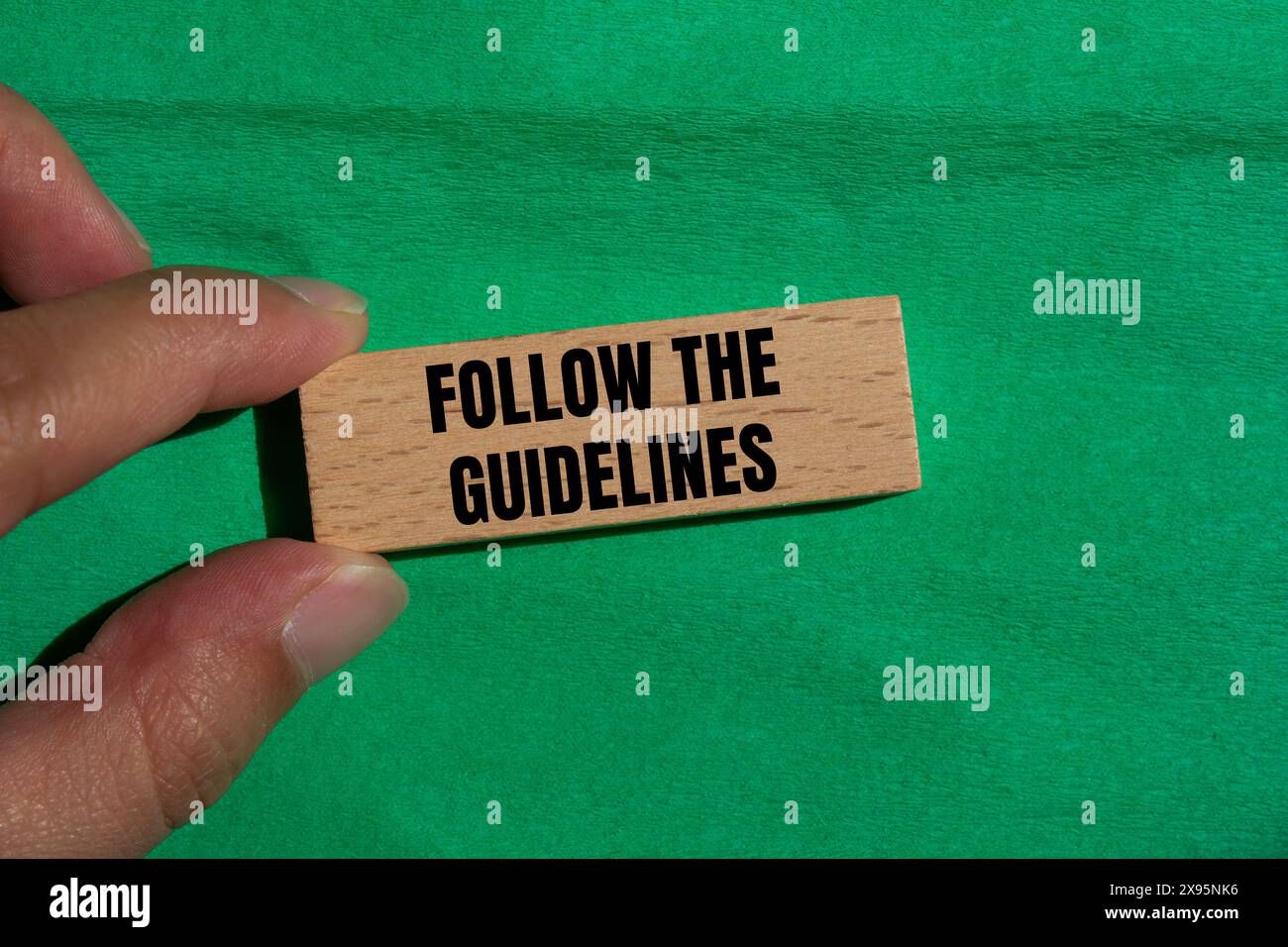 Follow the guidelines words written on wooden block with green ...