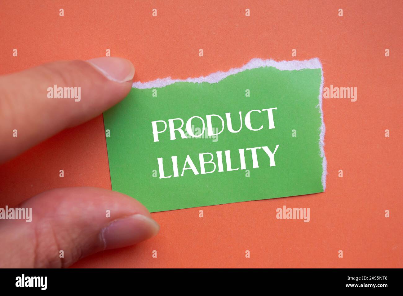 Product liability words written on ripped green paper piece with orange ...