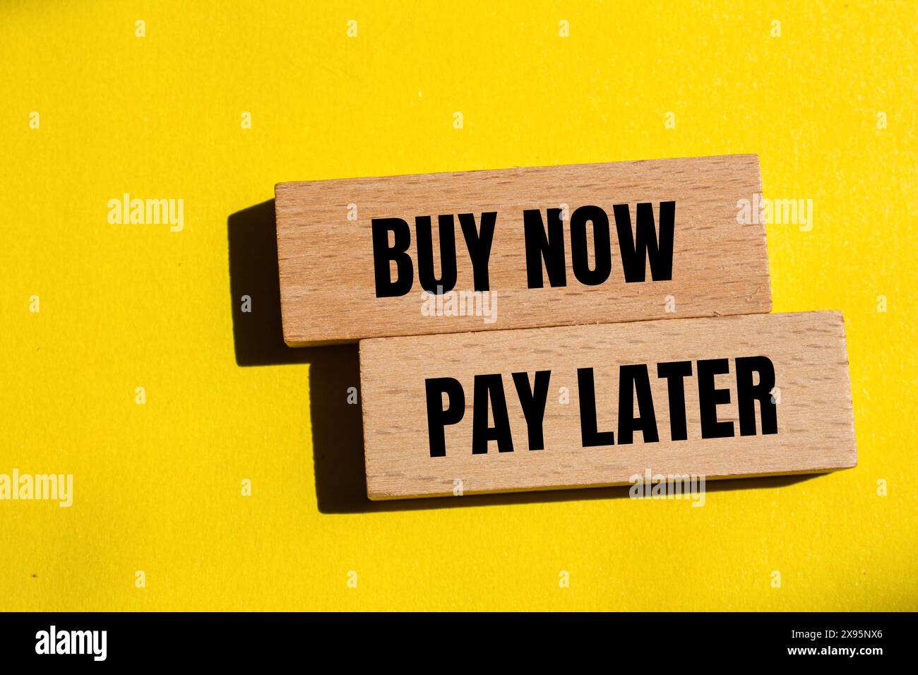 Buy now pay later words written on wooden blocks with yellow background ...