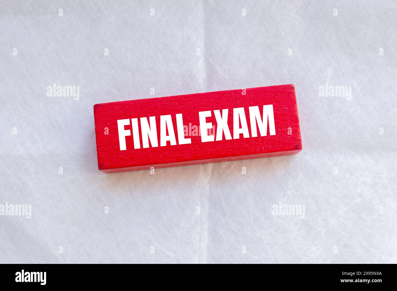 Final exam words written on red wodoen block with white background ...