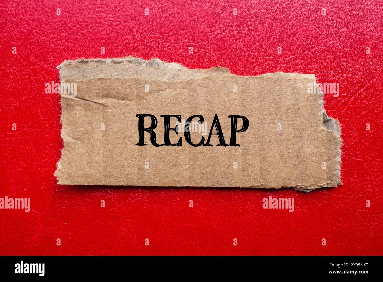 Recap word written on ripped cardboard paper piece with red background. Conceptual recap word ...