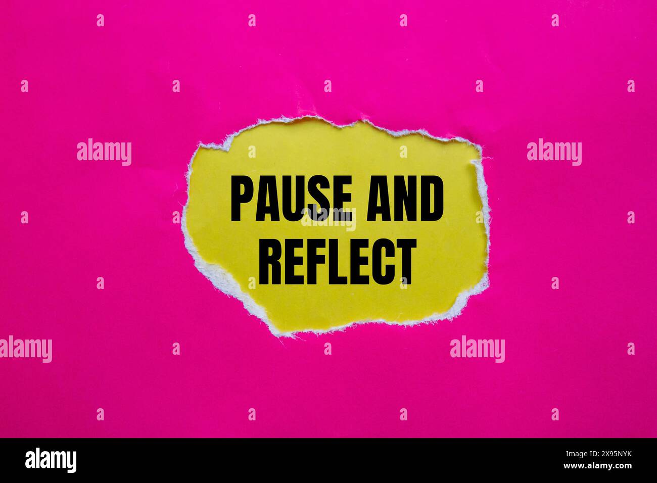 Pause and reflect words written on ripped pink paper with yellow ...