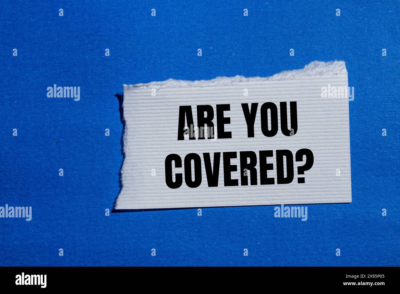 Are you covered ? words written on ripped white paper piece with blue ...