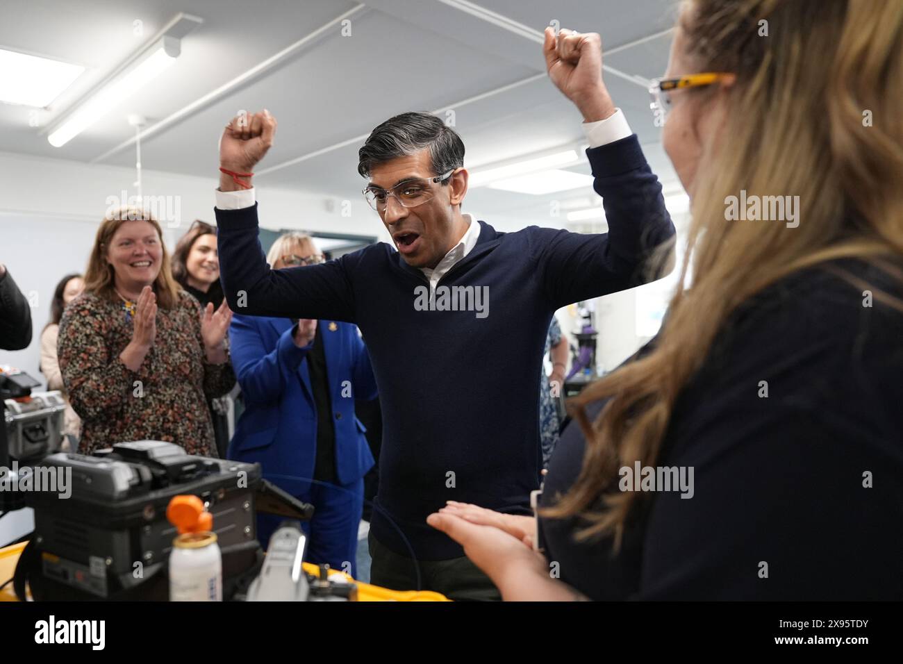 Prime Minister Rishi Sunak celebrates after being shown how to splice a ...