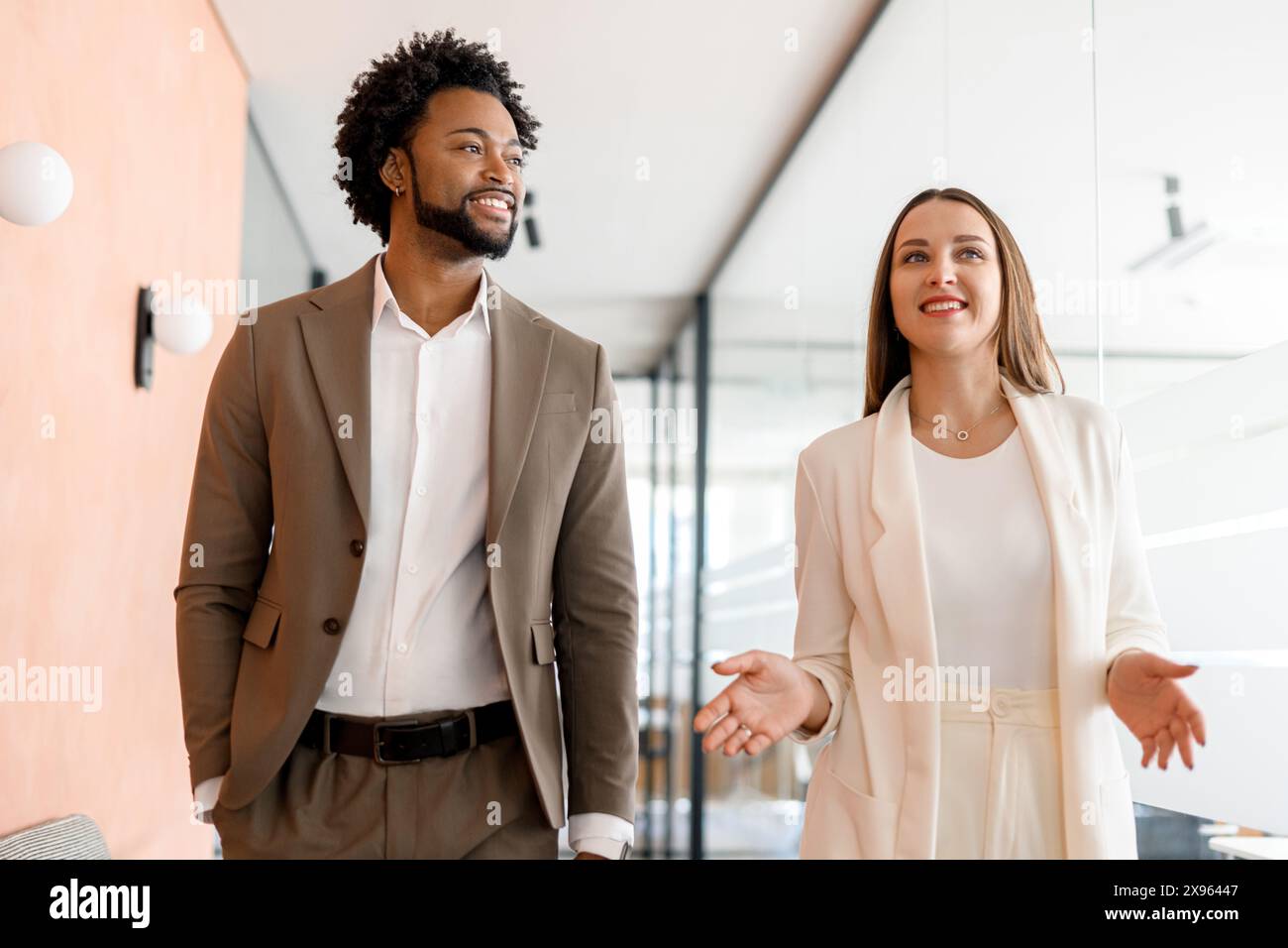 The businessman walks alongside a female colleague in a light and ...