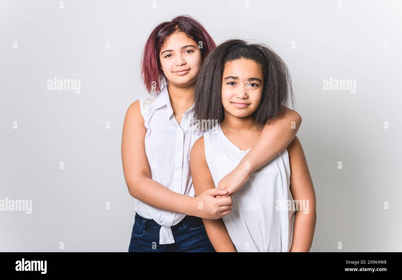 portrait of two beautiful sister over studio background Stock Photo - Alamy
