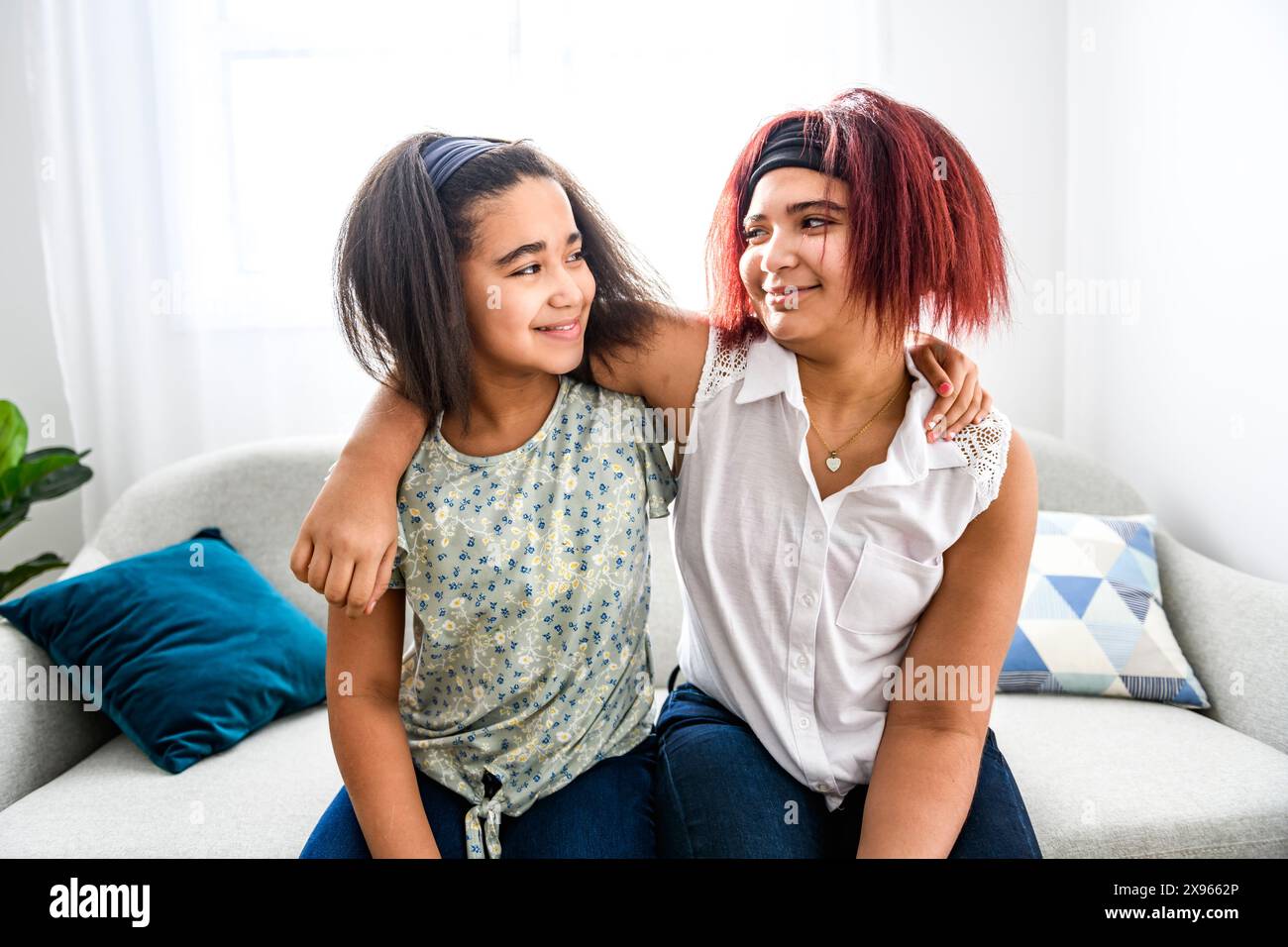 Two cute black sisters having great time on sofa at home Stock Photo ...