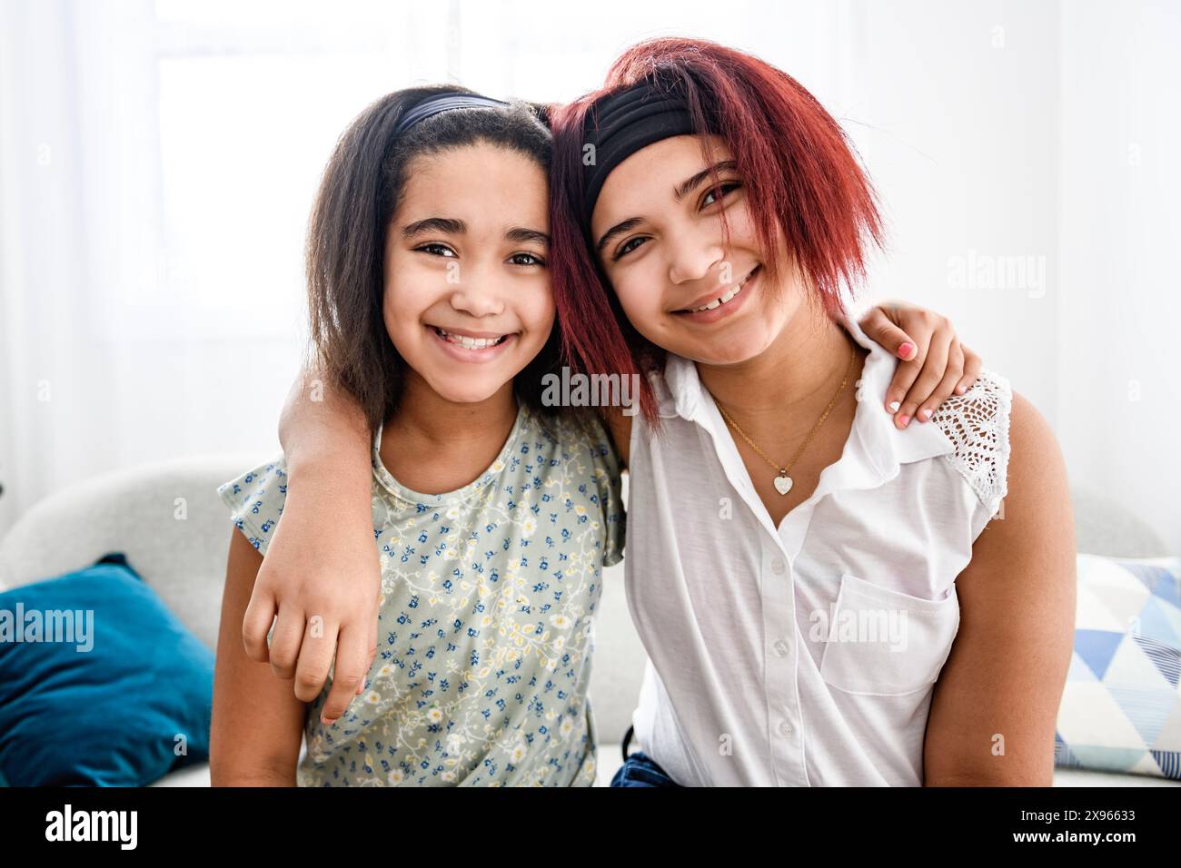 Two cute black sisters having great time on sofa at home Stock Photo ...