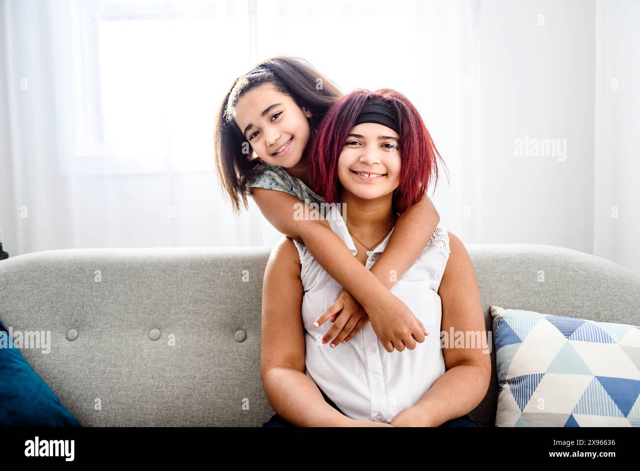 Two cute black sisters having great time on sofa at home Stock Photo ...