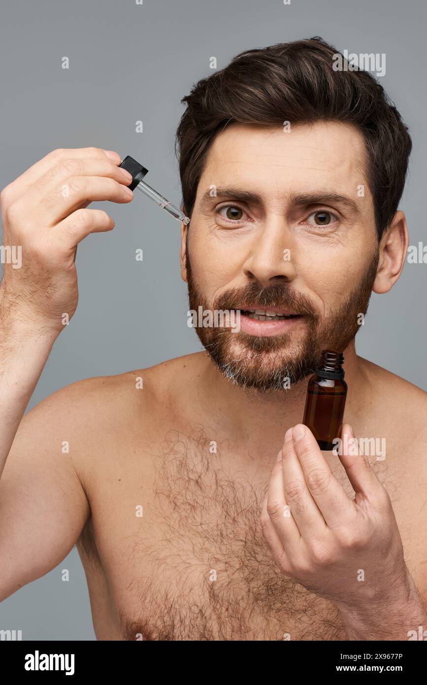 Bearded man applying serum on his face Stock Photo - Alamy
