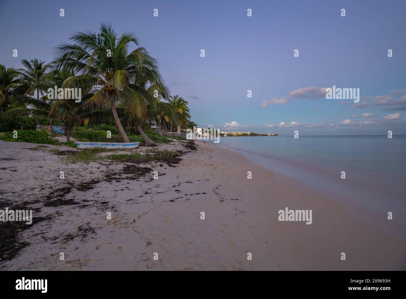 View of rustic canoe boat on beach at sunset near Puerto Morelos ...