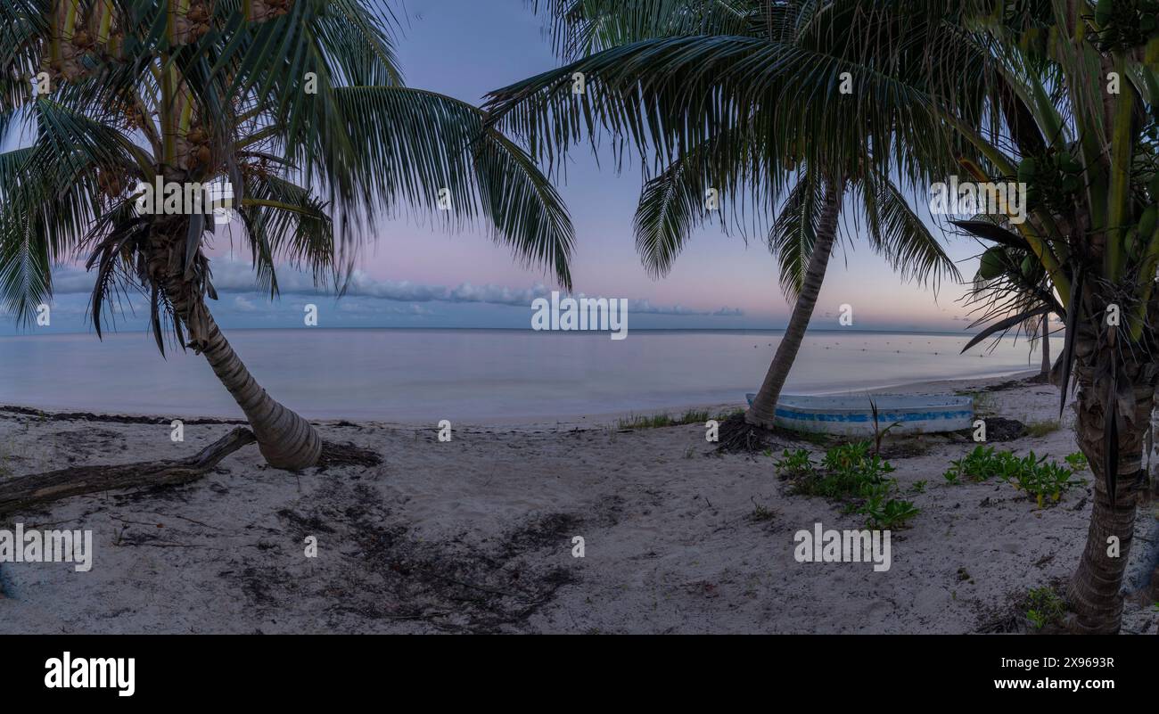 View of rustic canoe boat on beach at sunset near Puerto Morelos ...