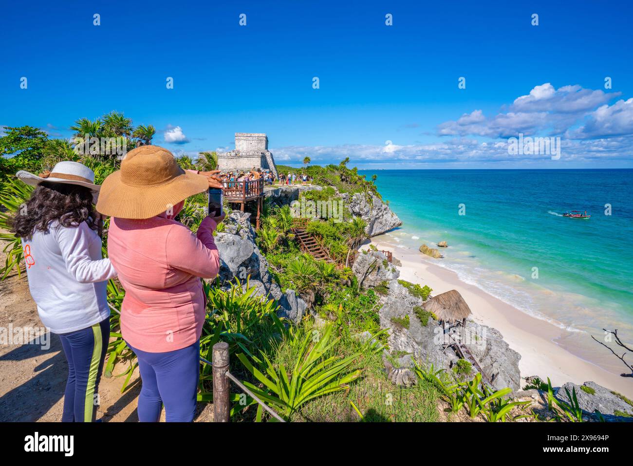 View of tourists and Mayan Temple ruins overlooking the sea, Tulum ...