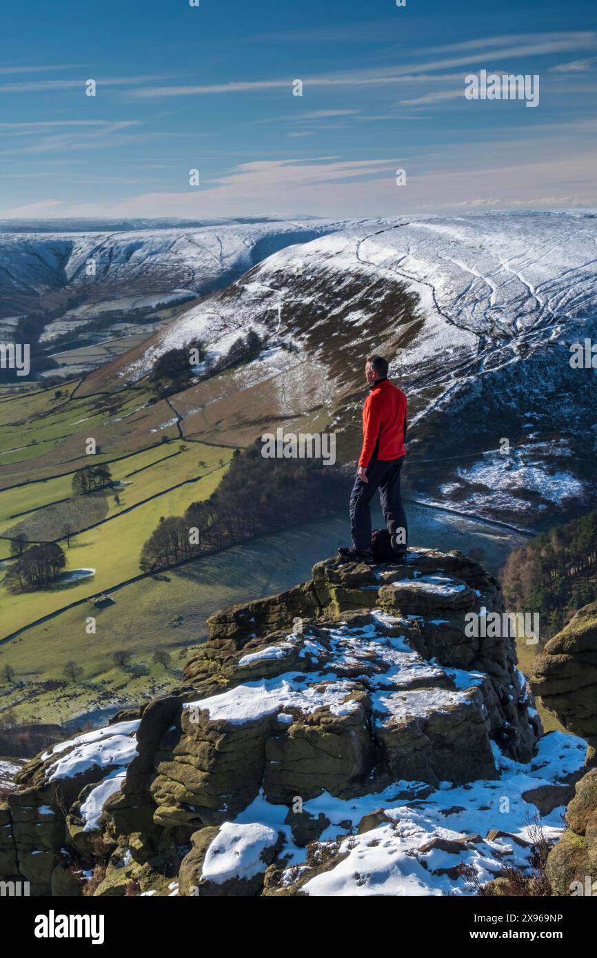 Walker looks out over the Edale Valley from Ringing Roger rock ...