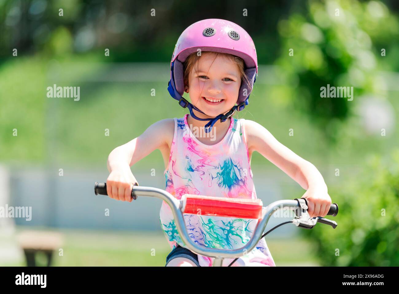 Children learning to drive a bicycle on a driveway outside. Little ...