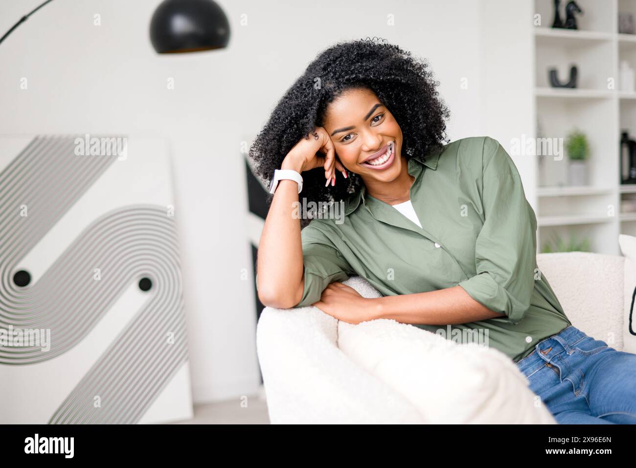 With a hand resting on her cheek, an African-American woman showcases a ...