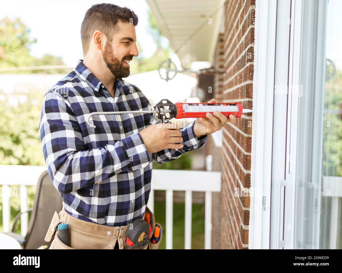 handsome young man installing bay window in a new house construction ...