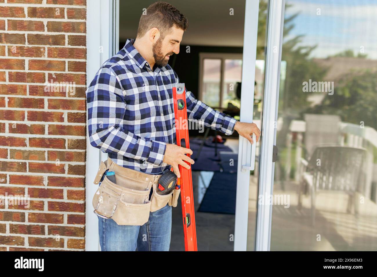 handsome young man installing bay window in a new house construction ...