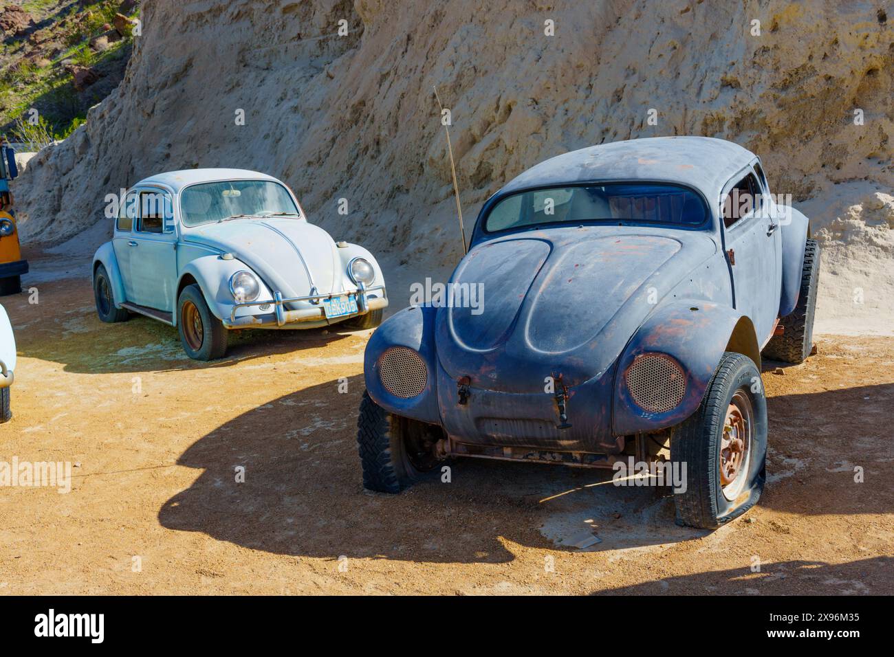 Nelson, Nevada - April 15, 2024: Close-up view of two small weathered vintage beetle cars in ...