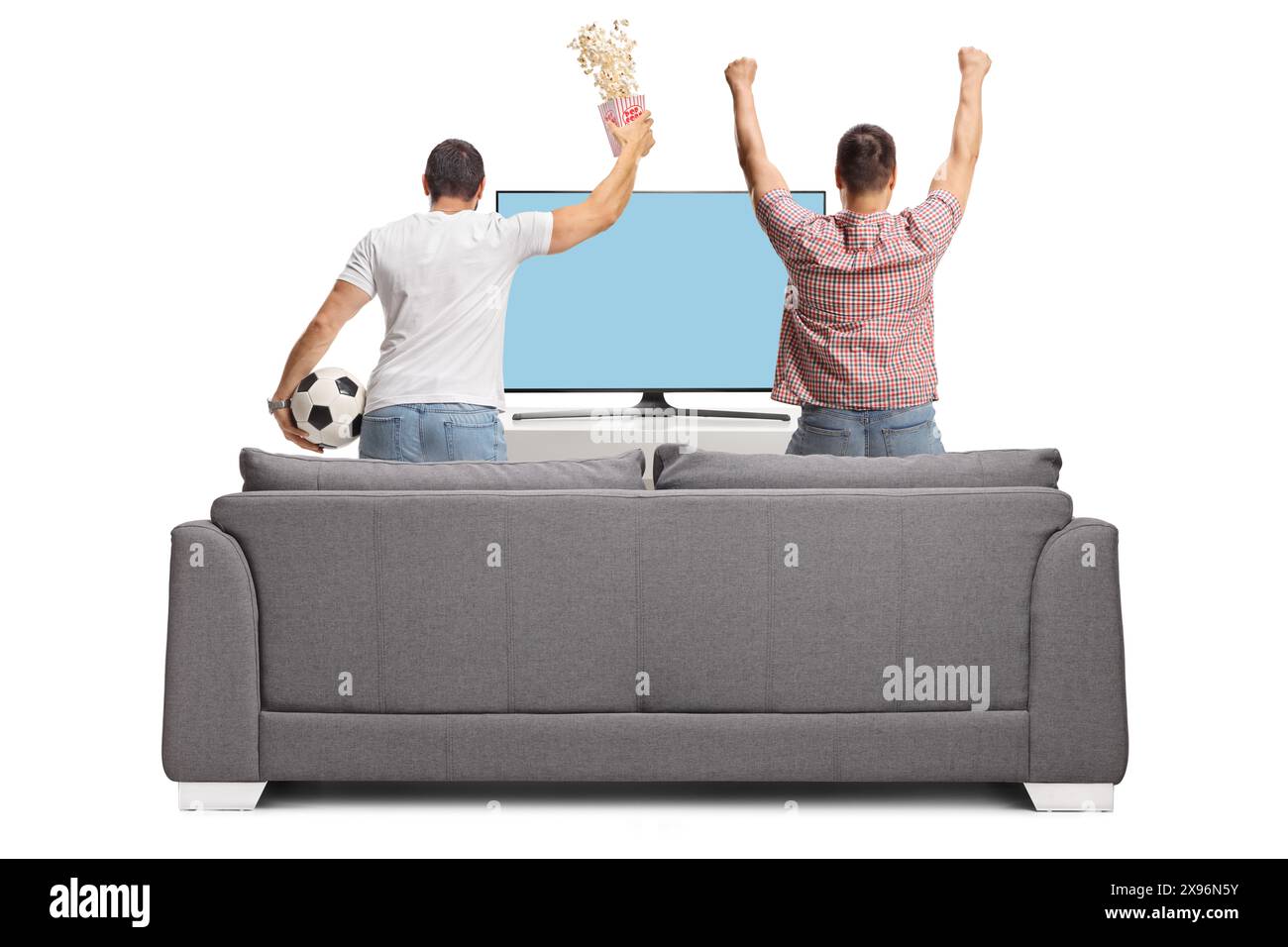Guys watching tv and cheering in front of a sofa isolated on white ...