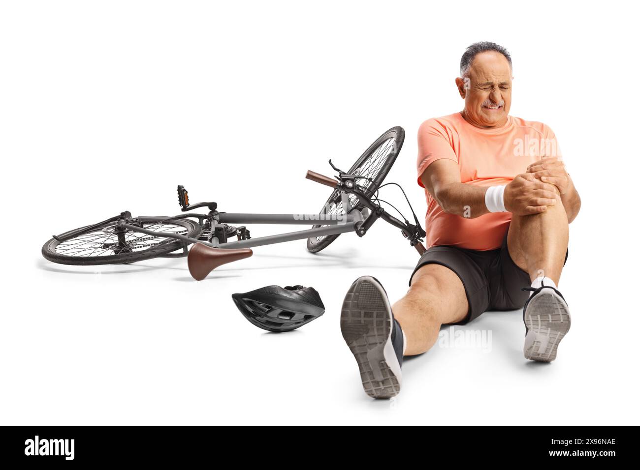 Mature man in pain falling from a bicycle and injuring his knee ...