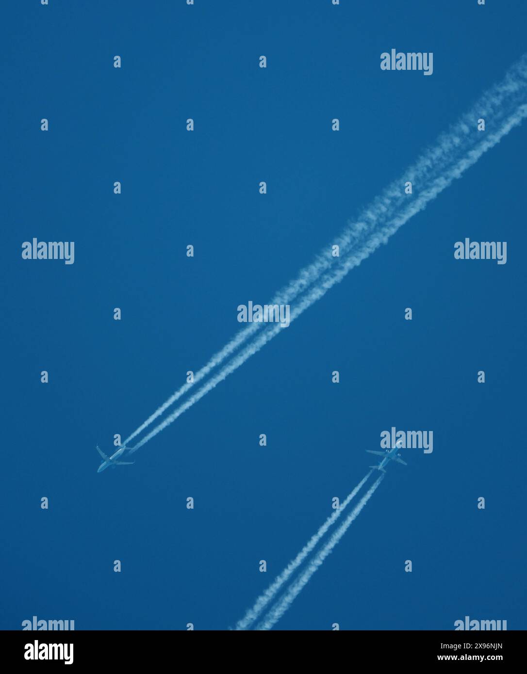 two planes in the sky, two airplane tracks in the blue sky, contrails ...