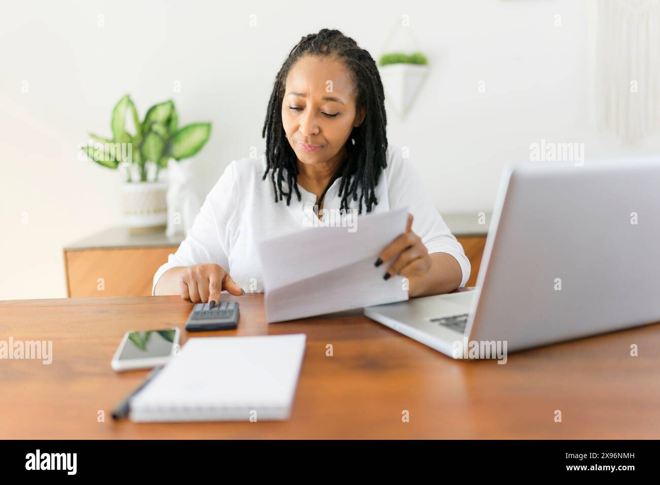 black woman using computer in modern kitchen interior Stock Photo - Alamy