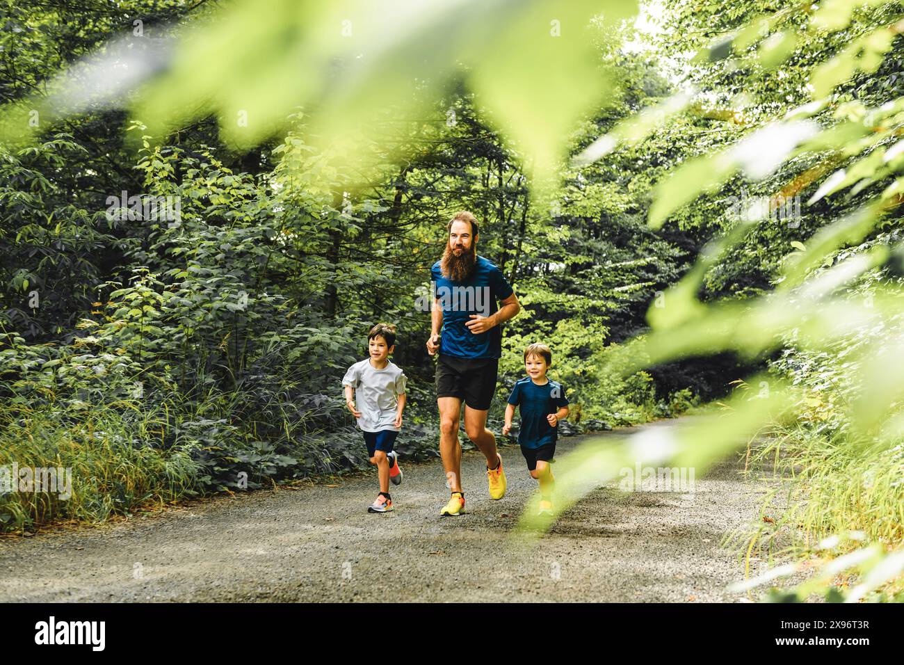 father and two sons running outside in forest Stock Photo - Alamy