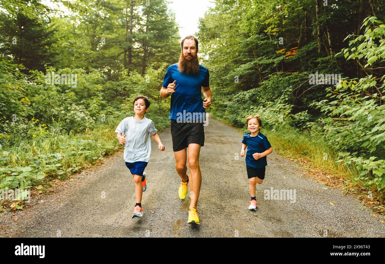 father and two sons running outside in forest Stock Photo - Alamy