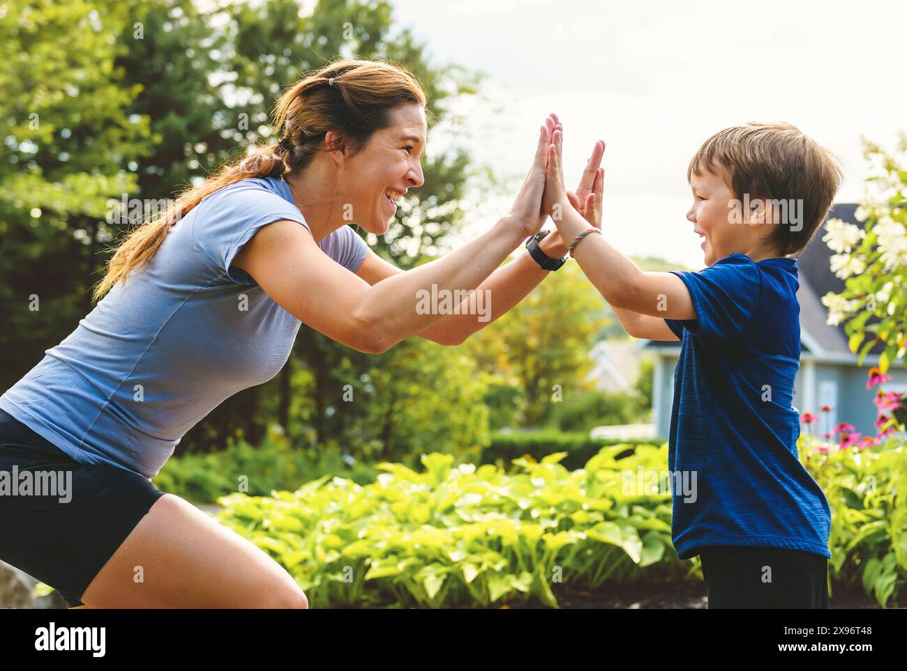 mother and son running outside in forest hiving high five Stock Photo ...