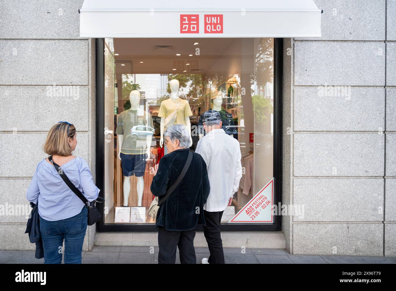 Shoppers seen window shopping at the Japanese clothing brand Uniqlo ...