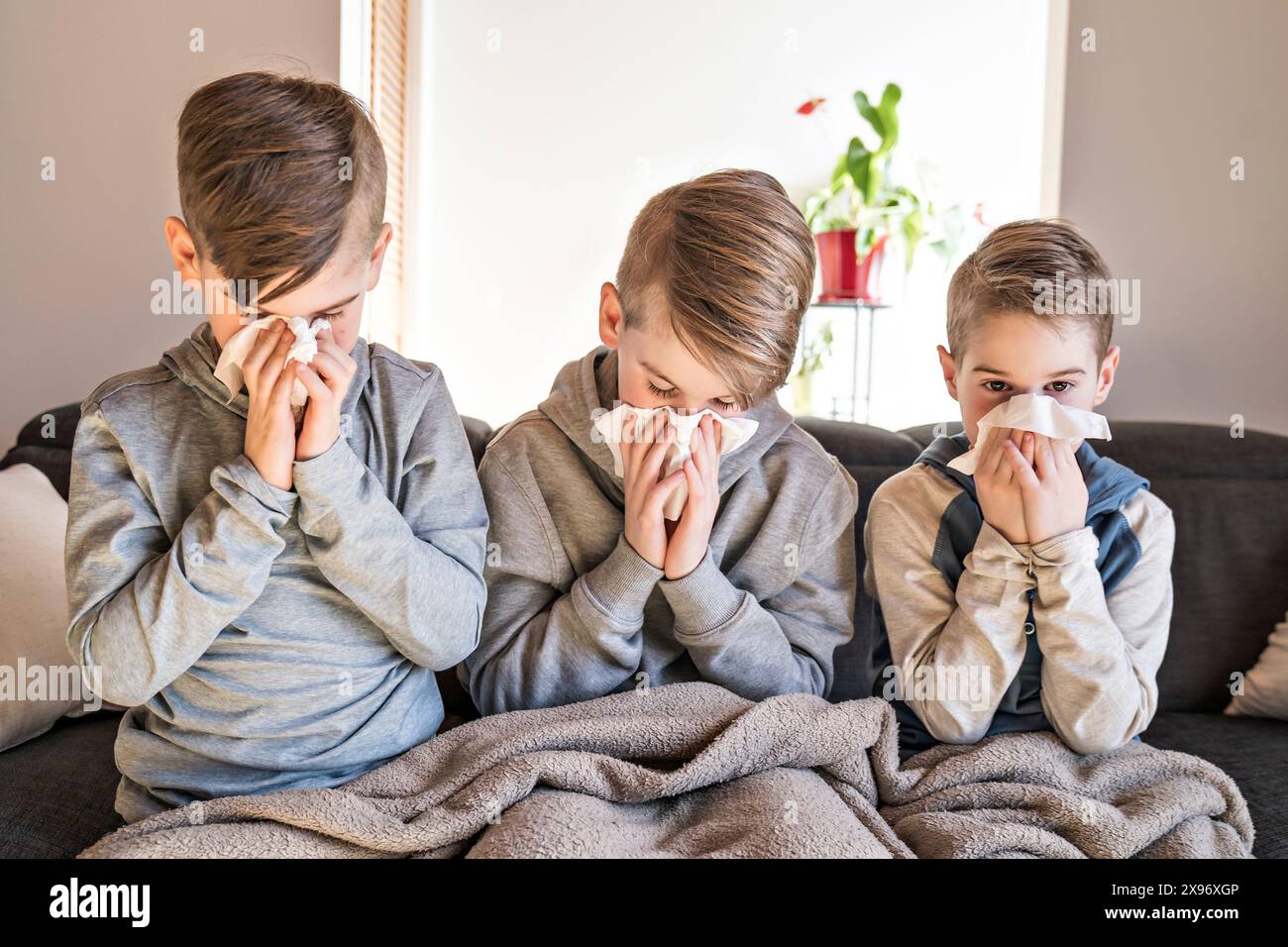 coughing little brothers boys at home having flu on the sofa Stock ...