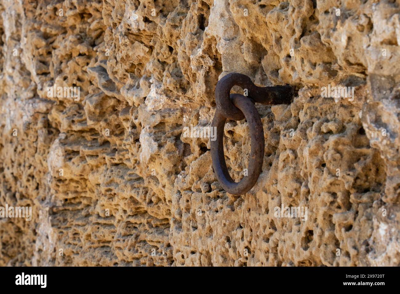A rusty metal tie ring for securing horses, stuck into the wall of an ...