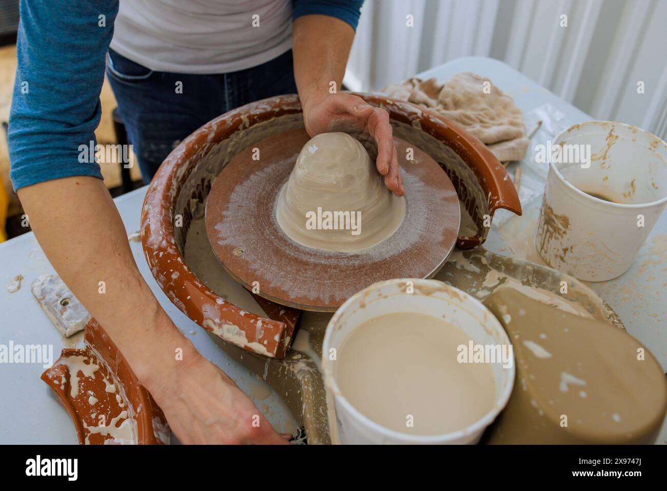 Working with wet soft clay on potter wheel, professional potter creates ...