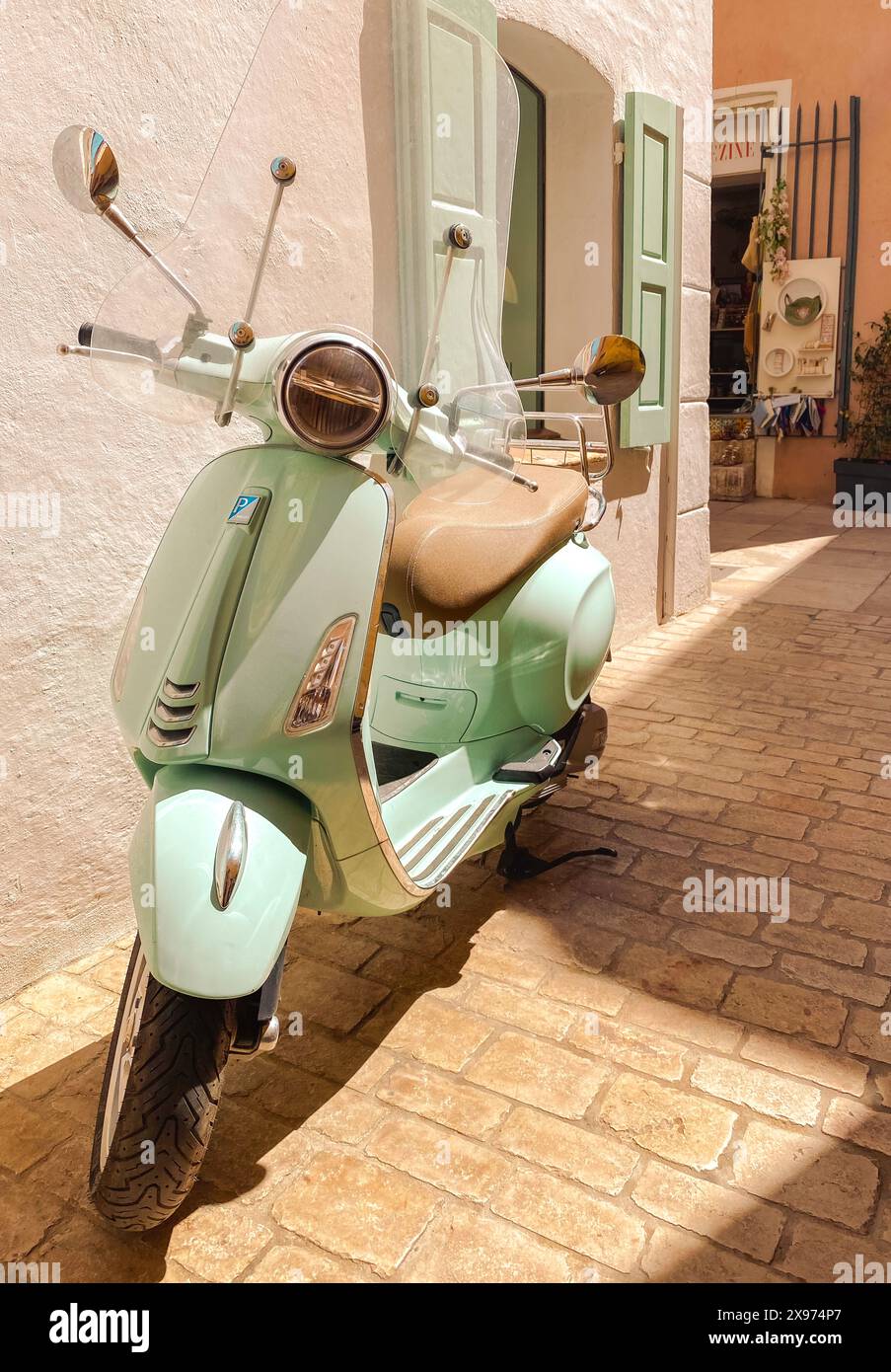 Vintage retro mint green stylish scooter parked on a quaint local ...