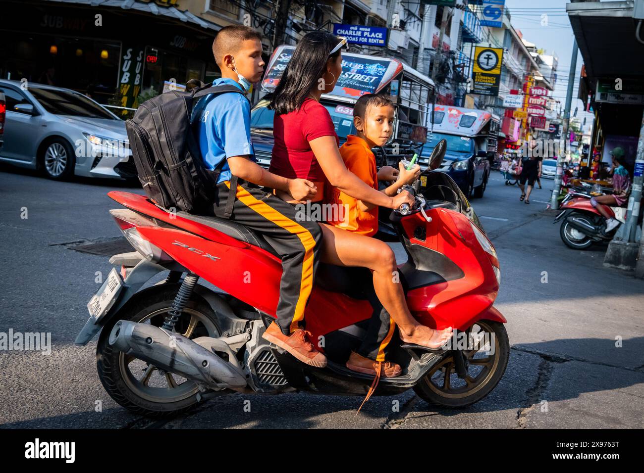Two Thai school kids heads home on a scooter in Pattaya Thailand ...