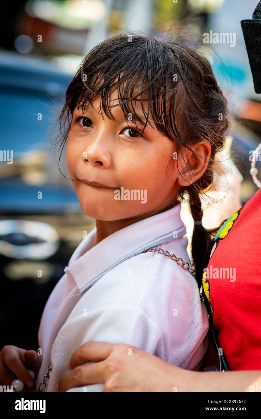 A Thai school girl heads home on the back of a scooter in Pattaya ...