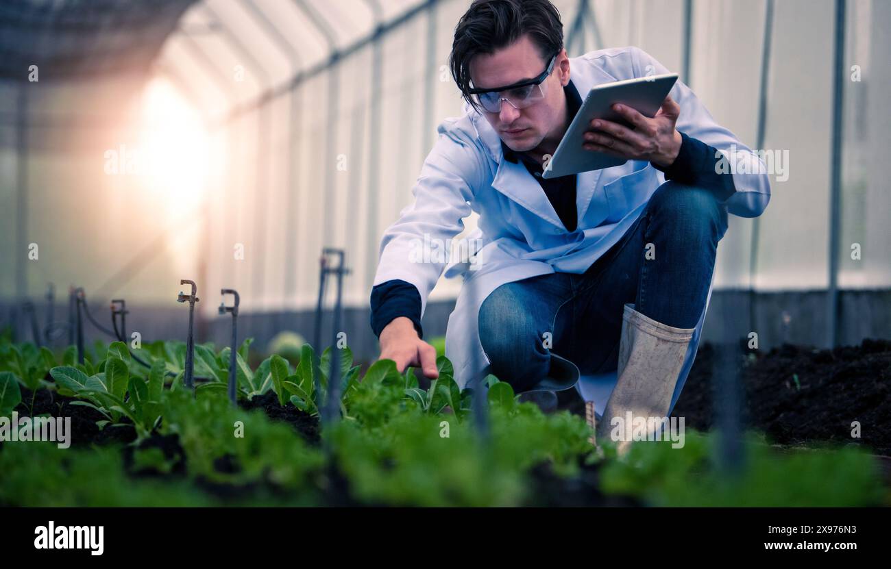 Portrait of handsome agricultural researcher holding tablet while ...