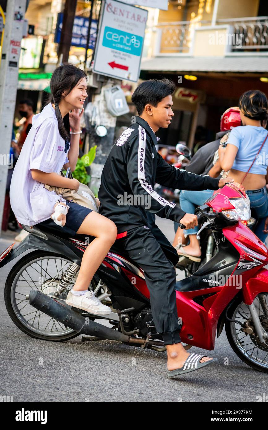 A Thai teenager school girl heads home on the back of a scooter in ...