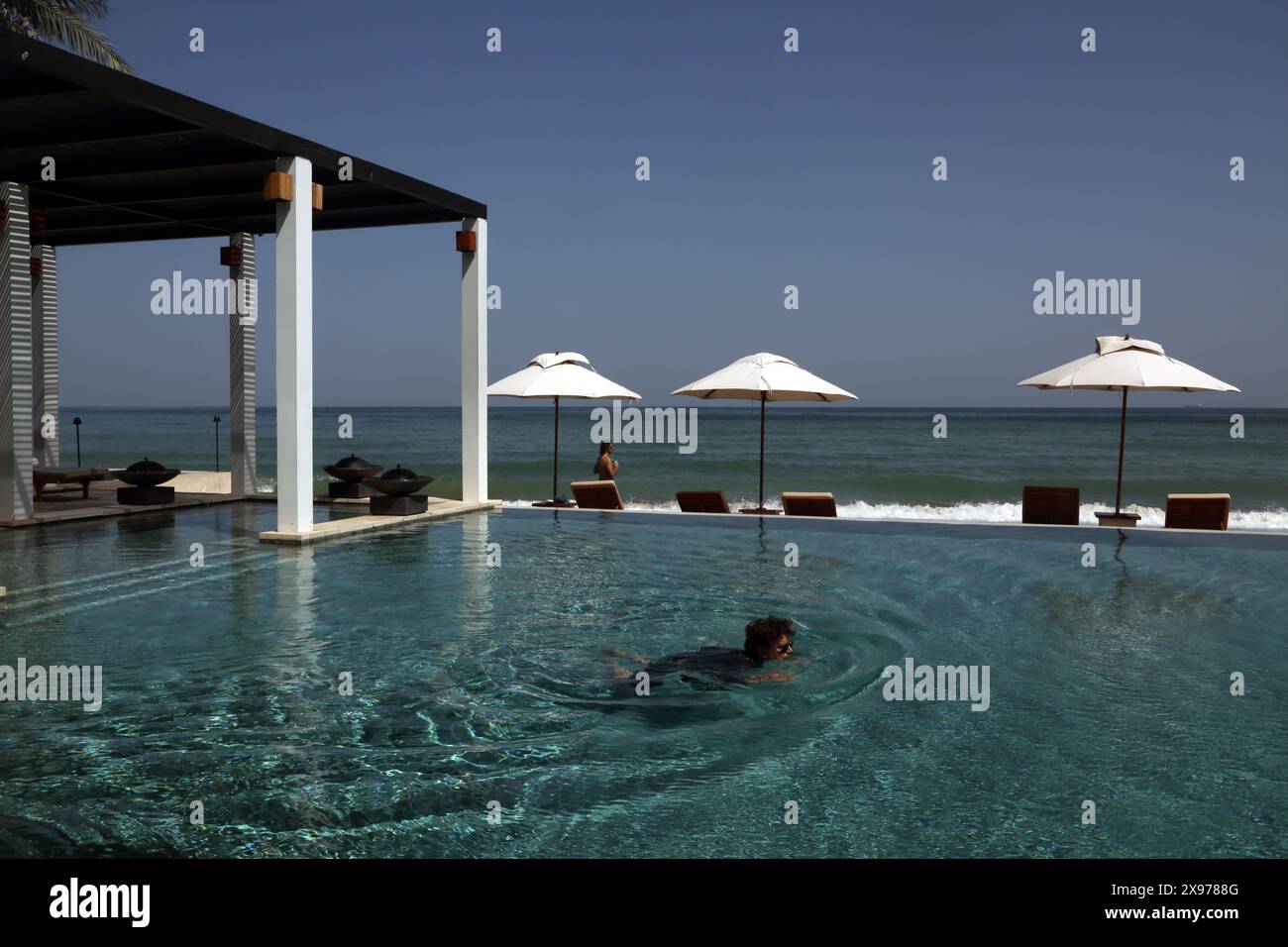 Tourist Swimming in Infinity Pool Looking out to the Gulf of Oman at ...