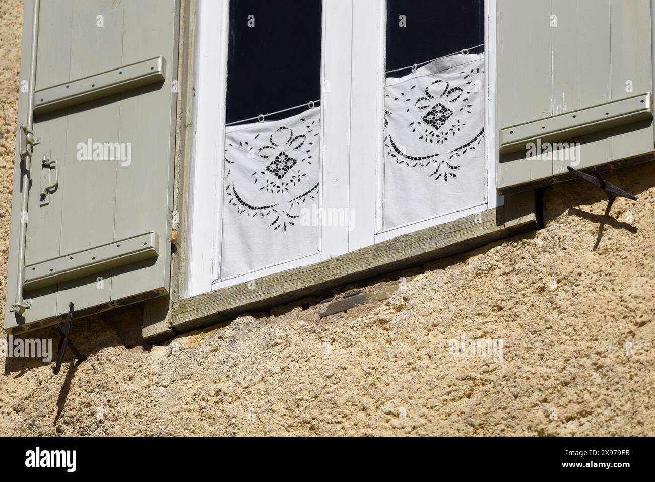 Rural house window with light grey wooden shutters and handmade cutwork ...