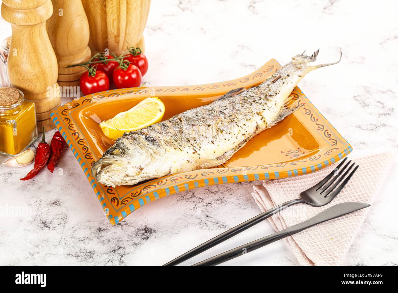 Grilled sea bass fish with spices served lemon Stock Photo - Alamy