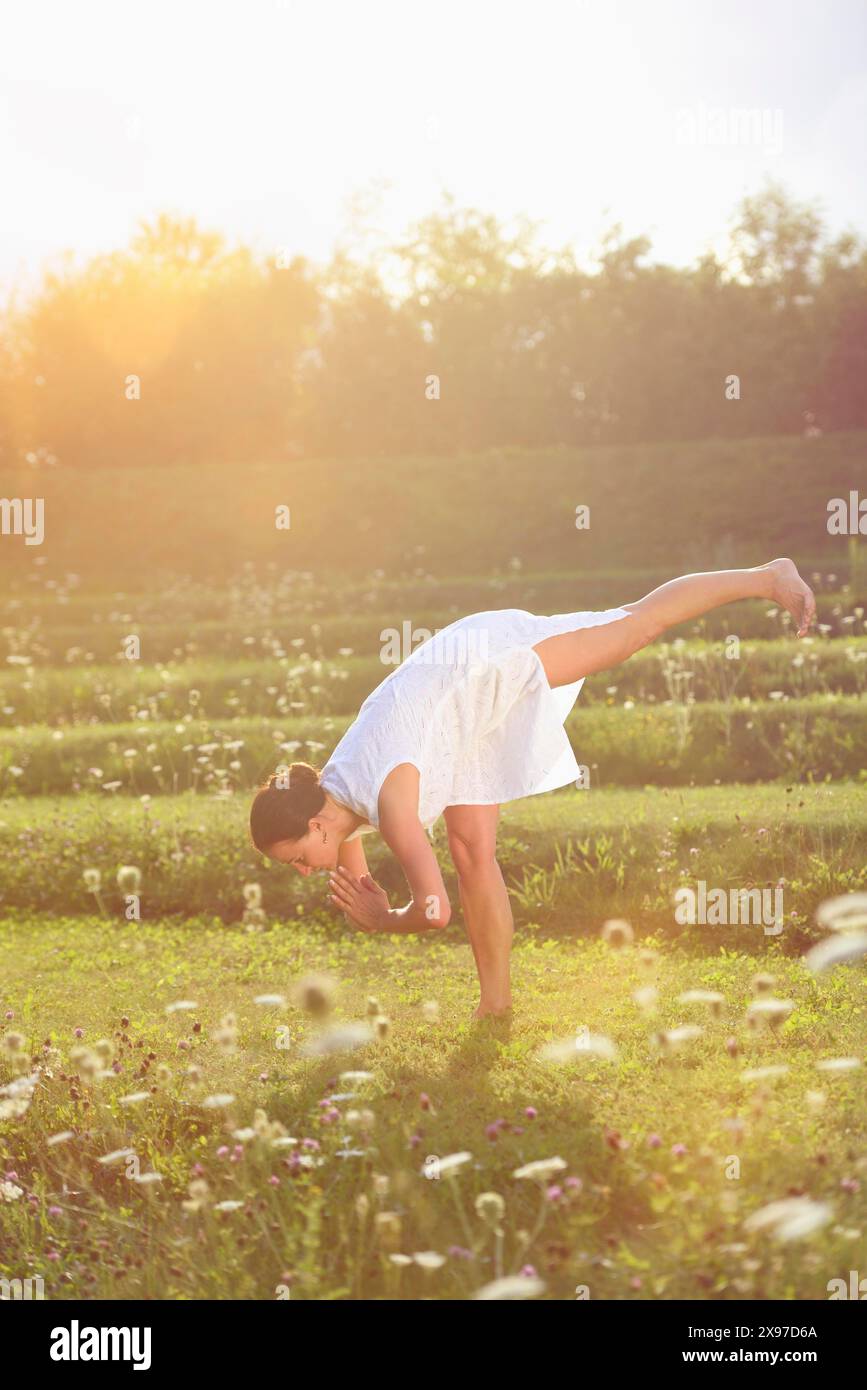 Middle aged woman doing yoga, the Standing Splits, Urdhva Prasarita Eka ...