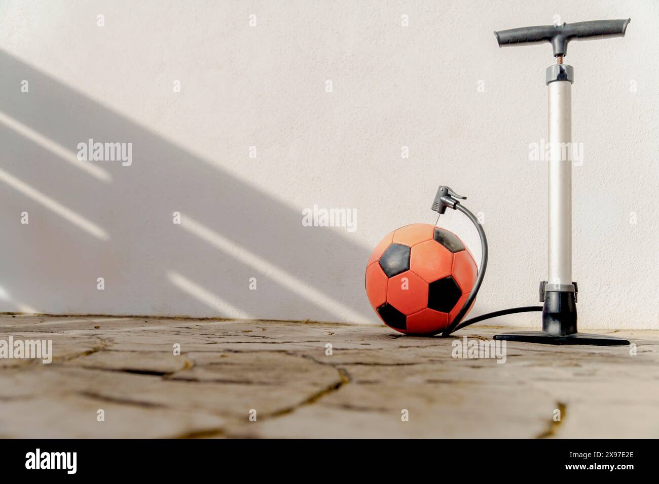 Hand pump inflating a red soccer ball with a white background Stock ...