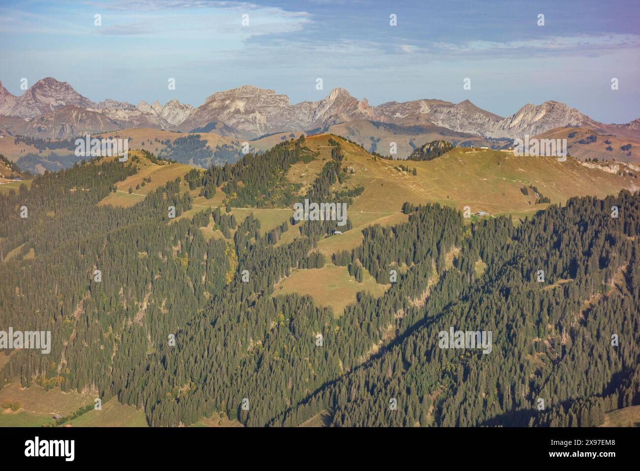 View of an extensive mountain range with deep valleys and dense forests ...