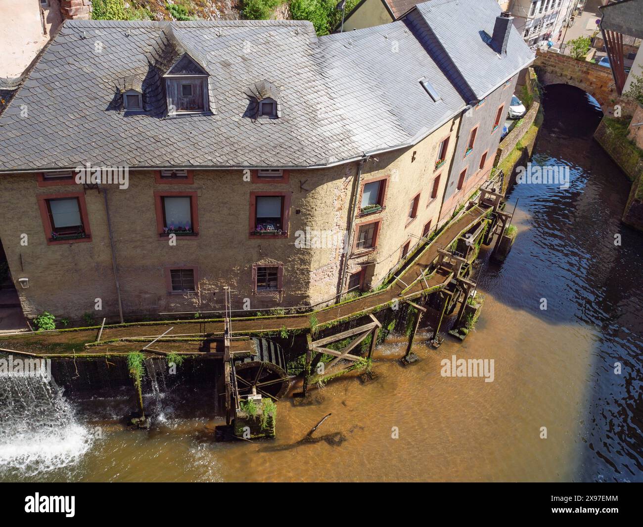 Historic building along a river with wooden structures and reflection ...