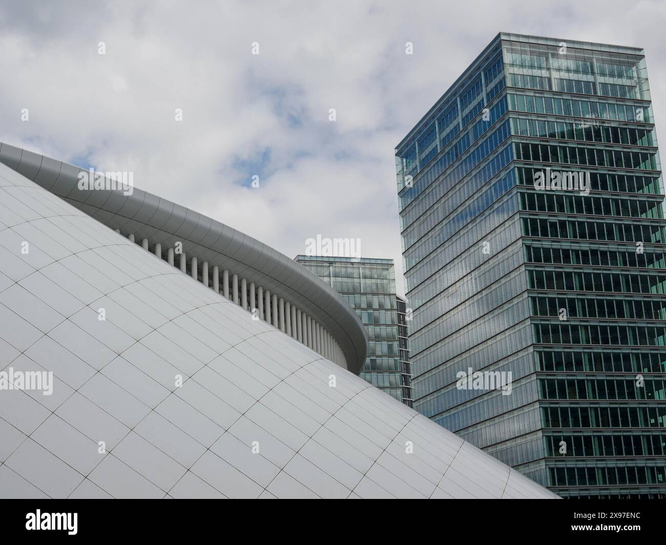 White arched structure in front of modern skyscrapers and glass facades ...