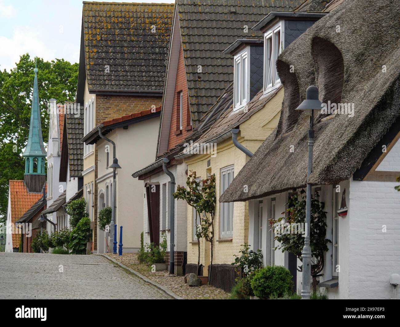 Traditional houses with thatched roofs and a pointed tower at the end ...
