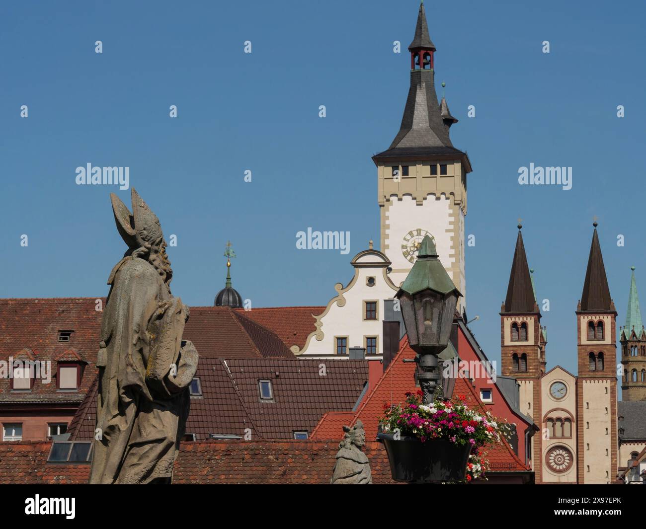 Historical statues in front of a clock tower with two church towers and ...
